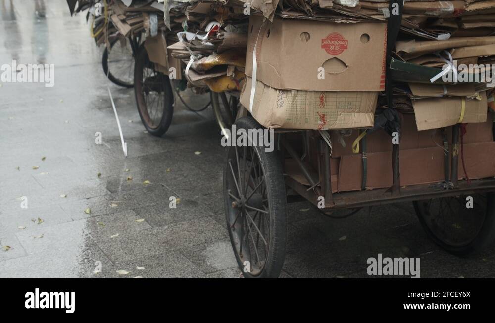 A parked rickshaw heavy loaded with carton boxes for recycling on a ...
