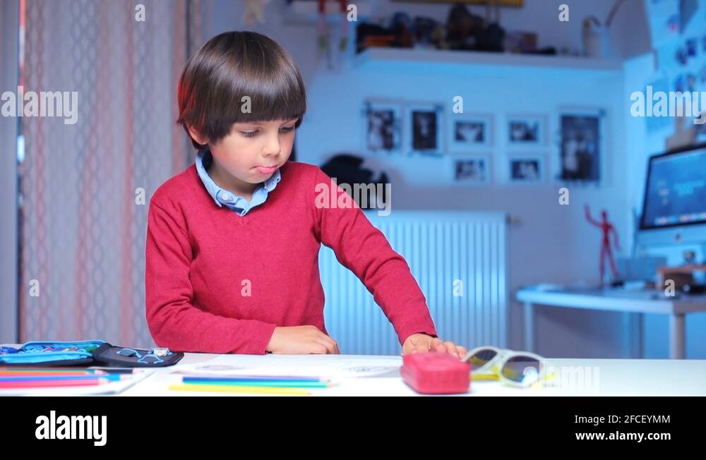 the child stands at the table, begins to draw a pencil drawing Stock ...