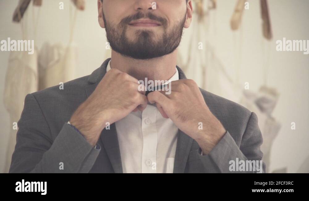 Man in formal suit getting dressed in dressing room for work or wedding ...