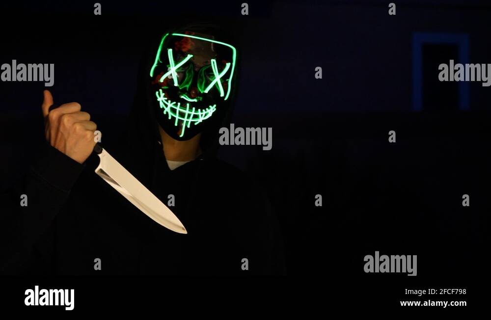 A scary slasher killer in a generic anonymous halloween horror mask ...