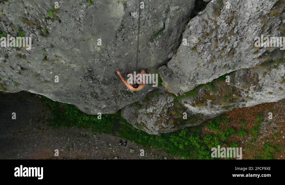Top Down View Of Shirtless Male Climber Rappelling Down Rock Face Stock ...