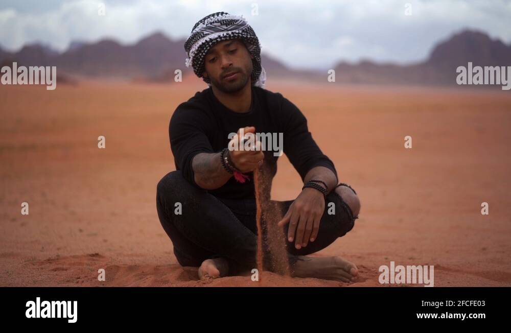 Arab man grabbing sand while escaping between his fingers Stock Video ...