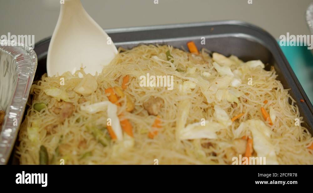 Gliding over the Filipino dish, pancit, and a tray of fried breaded ...