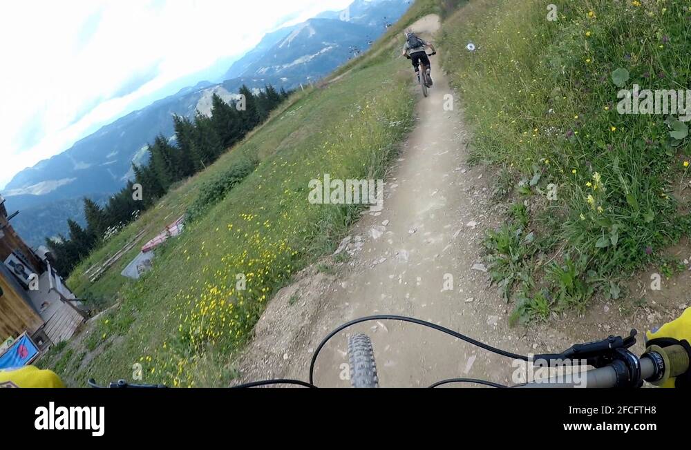 GoPro video of a man riding with his friend down a narrow trail Stock ...