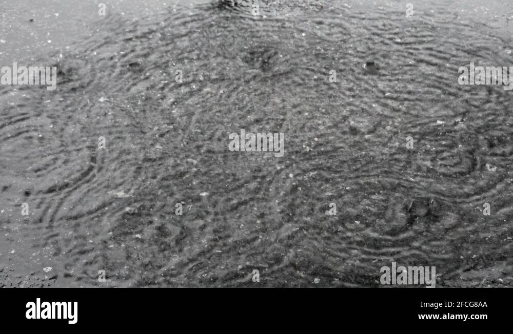 Rain drops falling into a puddle during a rain storm Stock Video ...