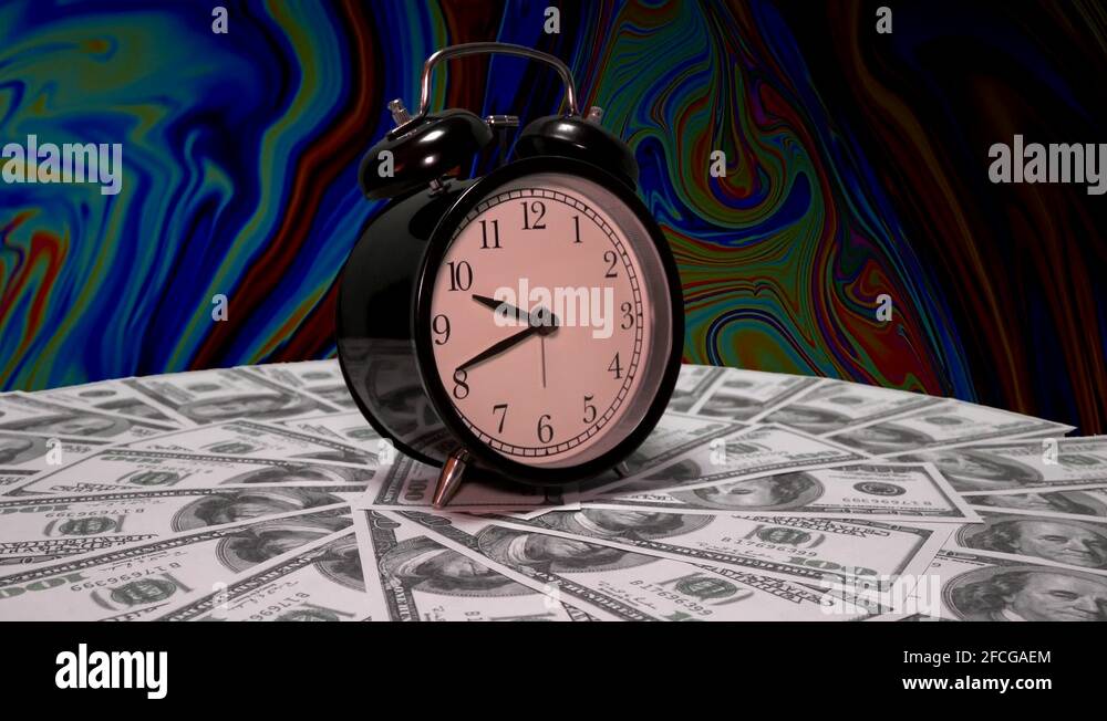 Alarm Clock rotating on hundred dollar bill bank notes with colorful ...