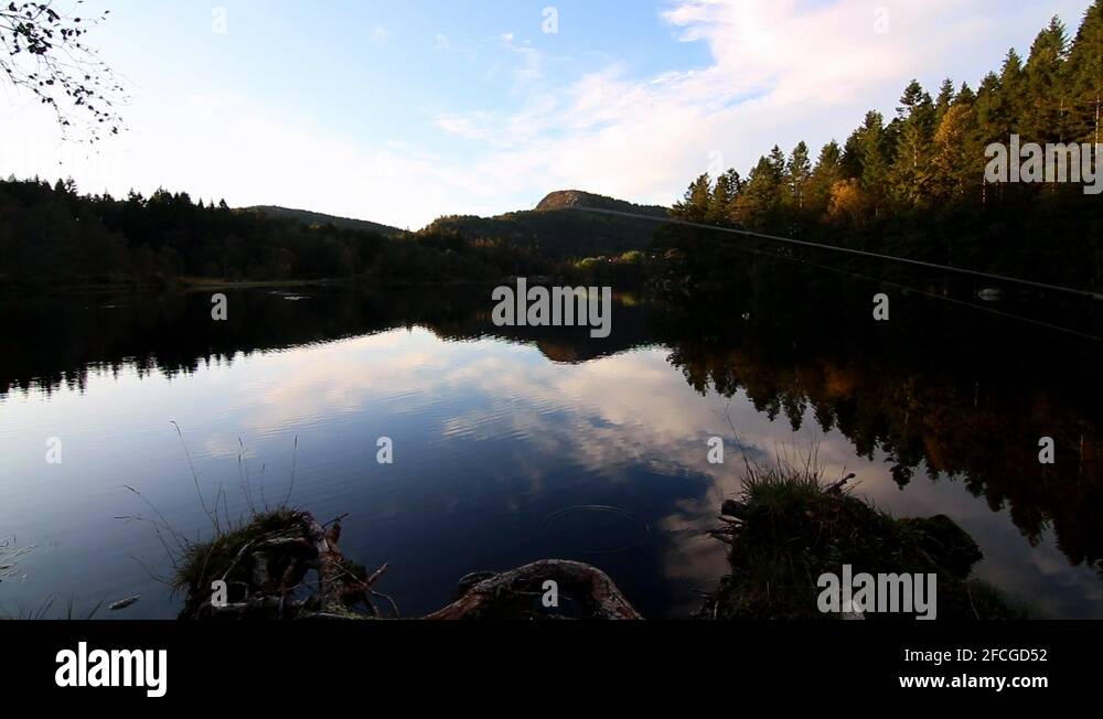 Casting a line and wait for a bite fishing in stunning freshwater lake ...
