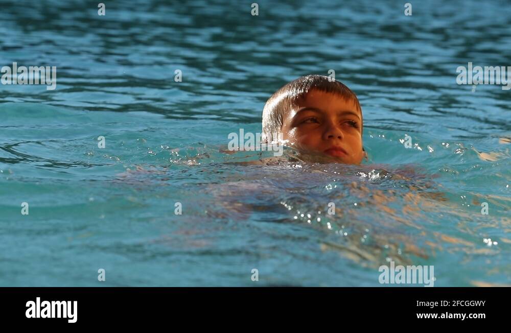 Young boy at the swimming pool water holding by poolside Stock Video ...