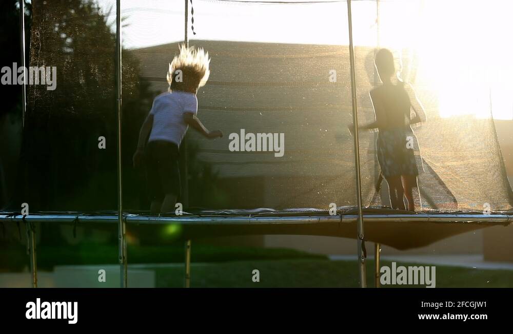 Kids bouncing in trampoline outdoors child falling down bumping and ...