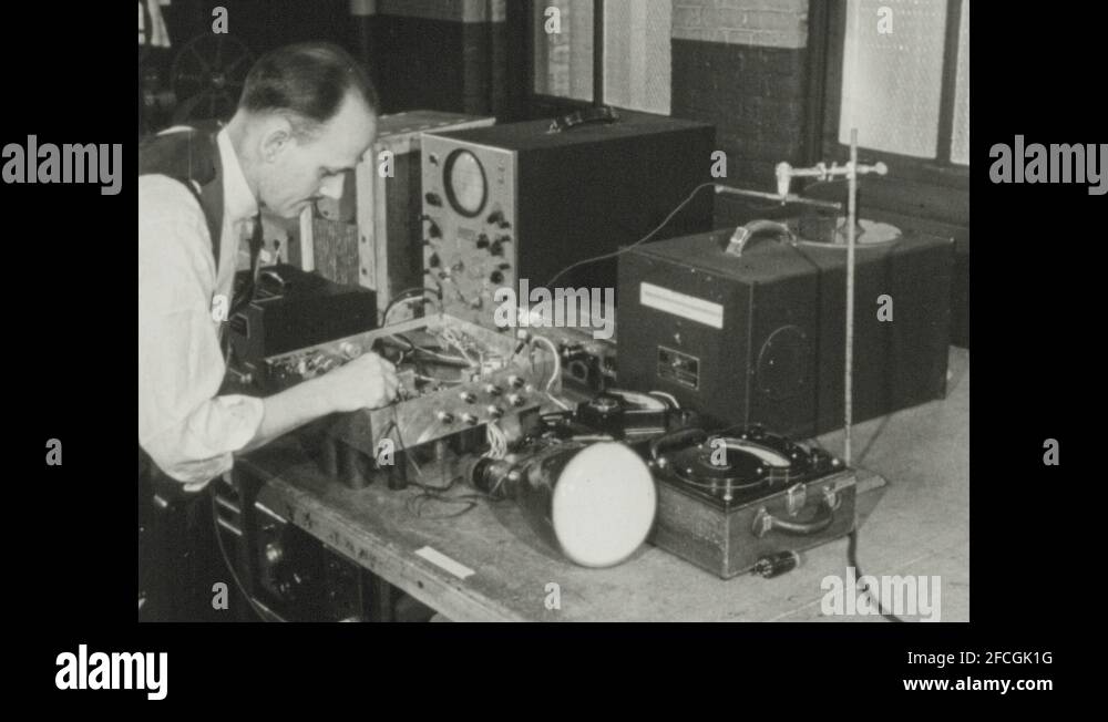 1940s: Lab, television receiver, man checks wiring. Men plug in cable ...