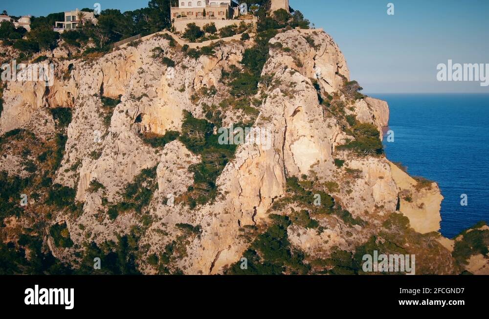 Sheer rocky cliffs line the coast with homes built on the rugged ...