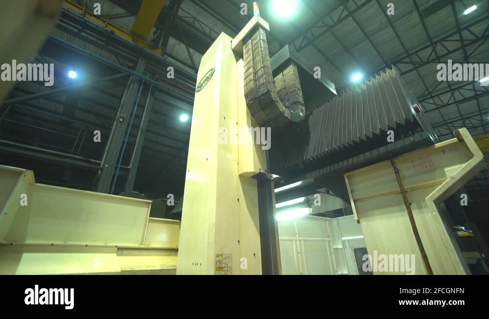 Tilt down shot reveals a heavy CNC automated milling machine doing ...