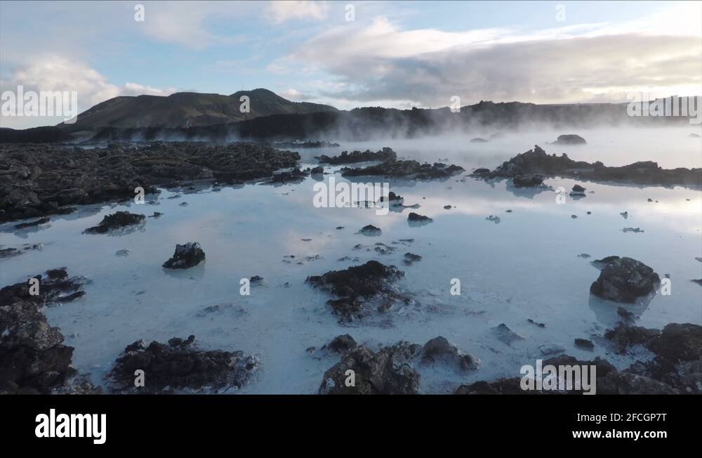 Steam coming out of the Blue Lagoon with a tall volcano in the ...