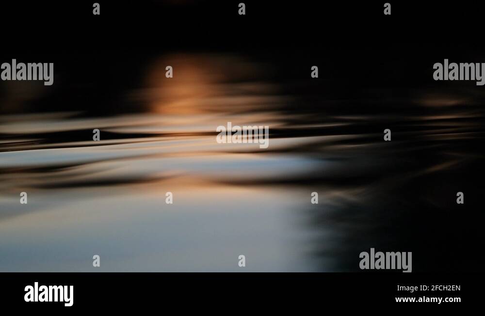 Liquid smooth lake water surface during sunset Stock Video Footage - Alamy