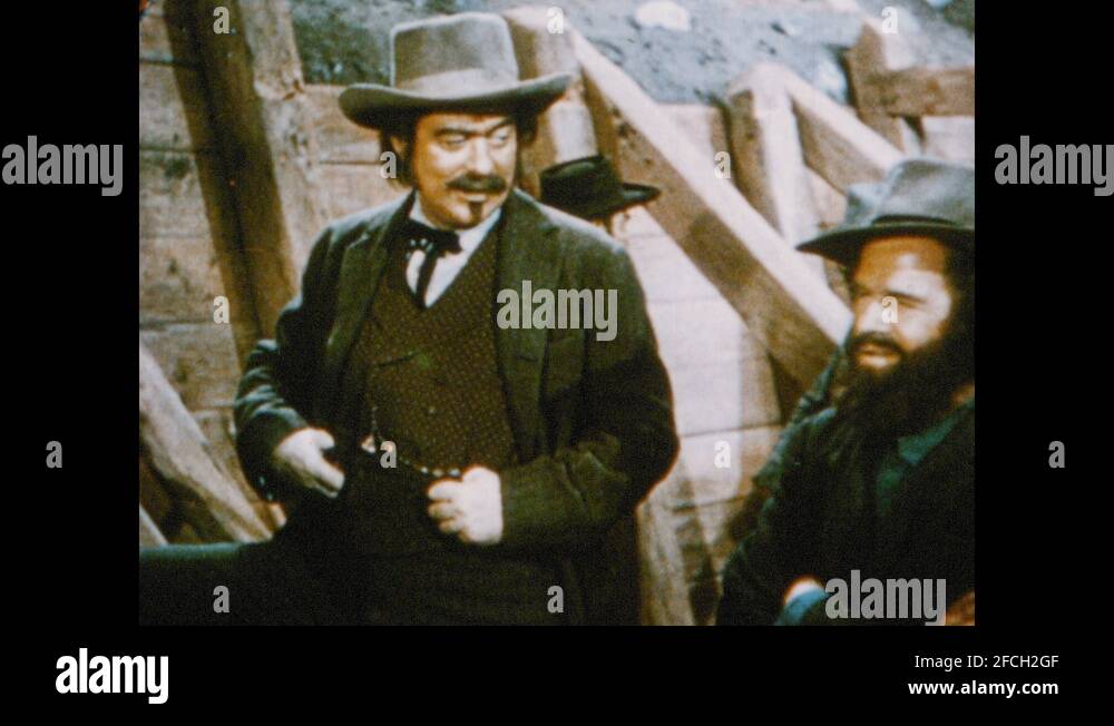 1950s: General John Sutter and man stand on steps of sawmill and talk ...