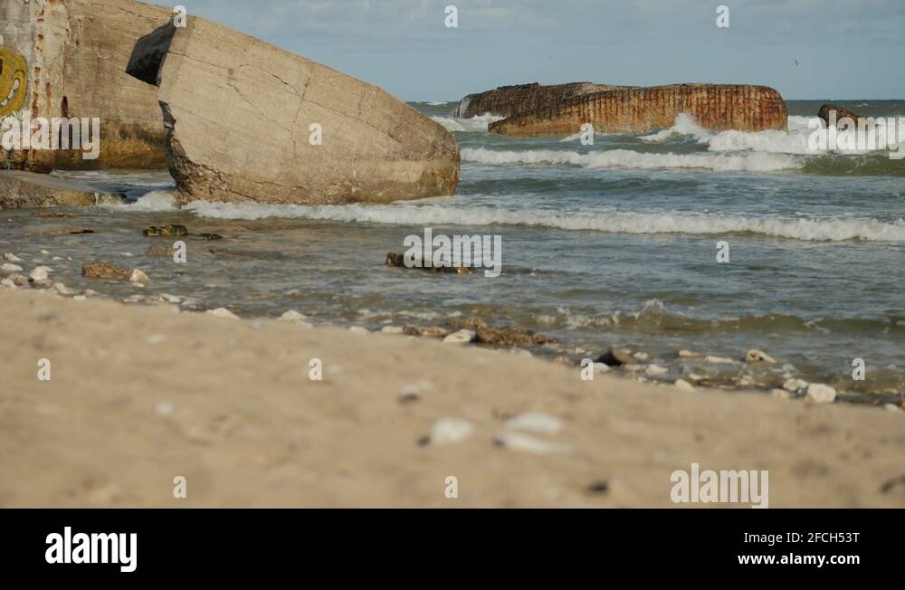 Old destroyed bunkers from ww2 at the beach with waves, birds and ...