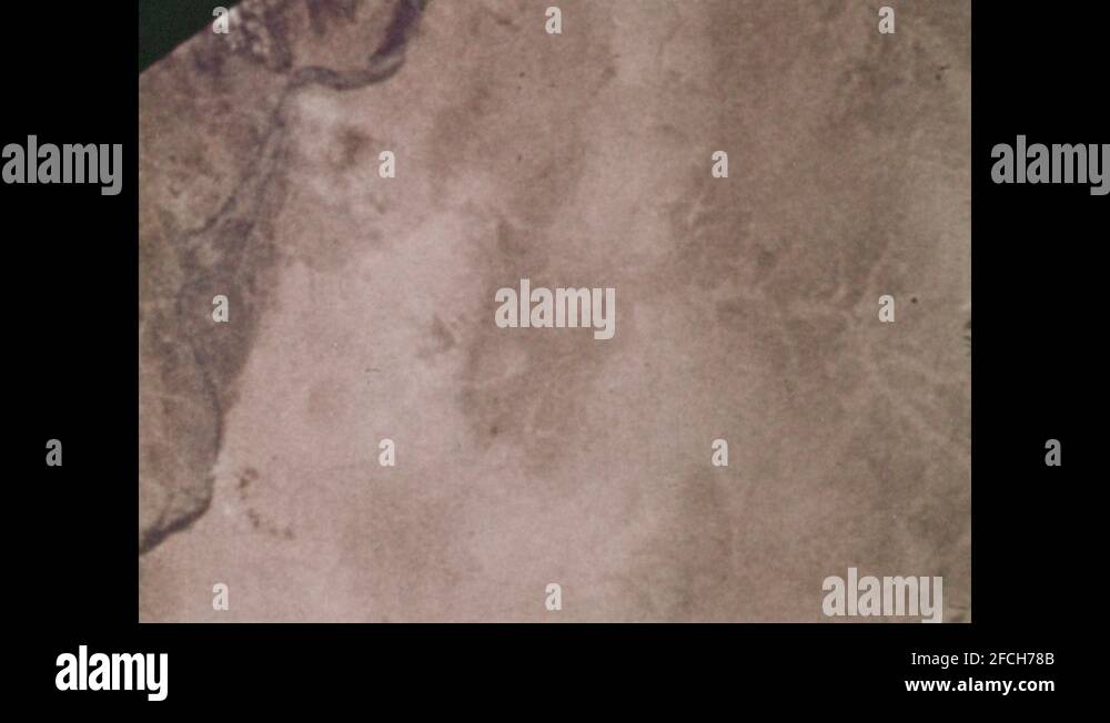 1970s: UNITED STATES: view of Earth from space. Man looks through maps ...