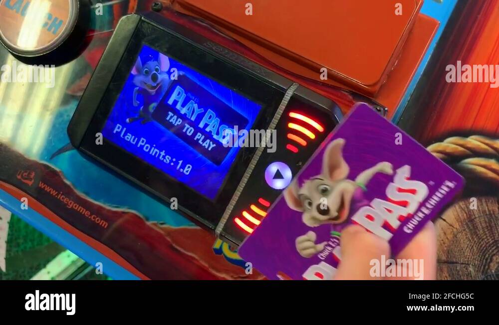 A small hand scanning a PLAY PASS at a Chuck E. Cheese arcade Stock ...