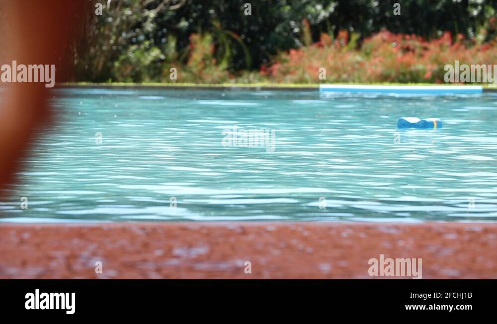 Two young boy running and jumping into swimming pool water in slow ...