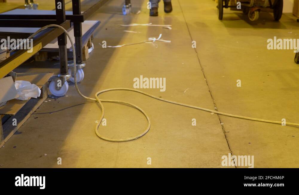 A low angle static footage showing a man walking over the wires laid on ...