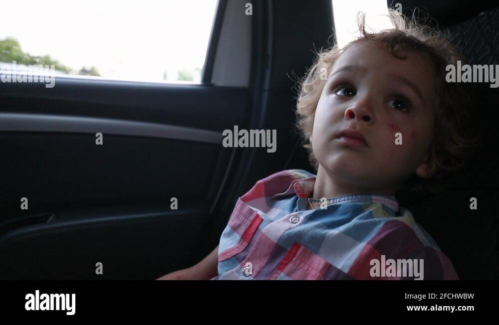 Kid in the backseat of a car. Passenger child boy looking out car ...