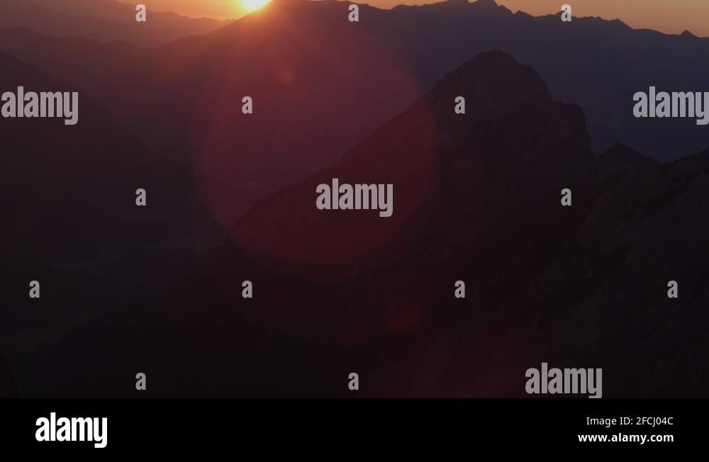 tilt from rock into rising sun lens flare Stock Video Footage - Alamy