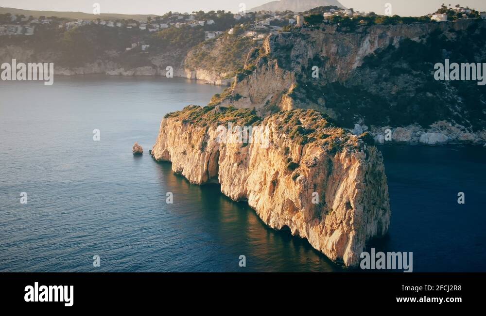 Cinematic cliff landscape with cave and white townscape, Aerial circle ...