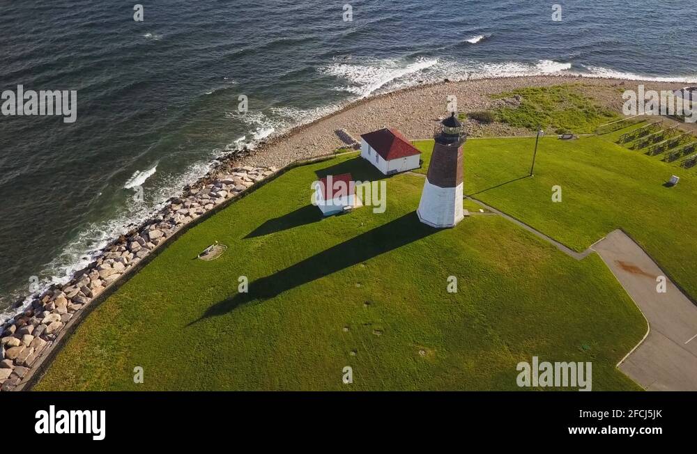 Lighthouse beacon across ocean aerial view tilt up to reveal horizon ...