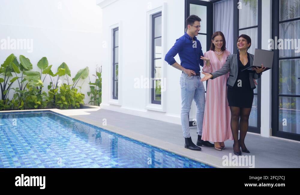 Real estate agent showing swimming pool on couple Stock Video Footage ...