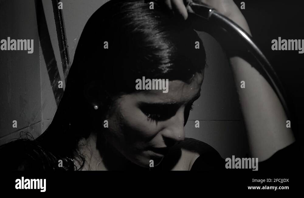Sad beautiful woman with long hair crying under the shower black and ...