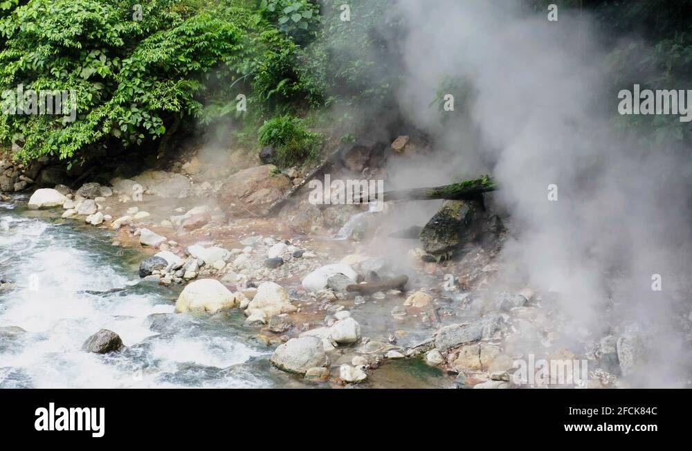Moving shot of volcanic hot springs flowing into the river in the ...