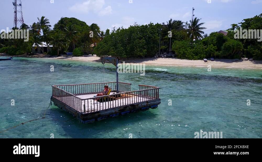 A beautiful young lady sitting in a swing chair built in a raft ...