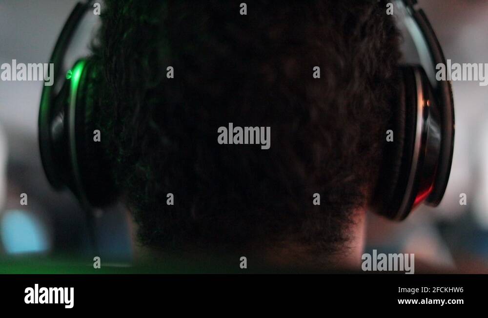 The back of person head wearing headphones listening to music. Man ...