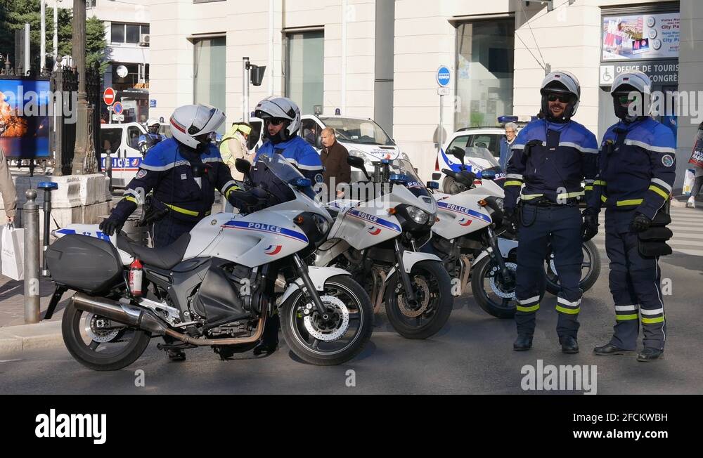 Four police officers in a blue uniform and wearing helmets gather in ...