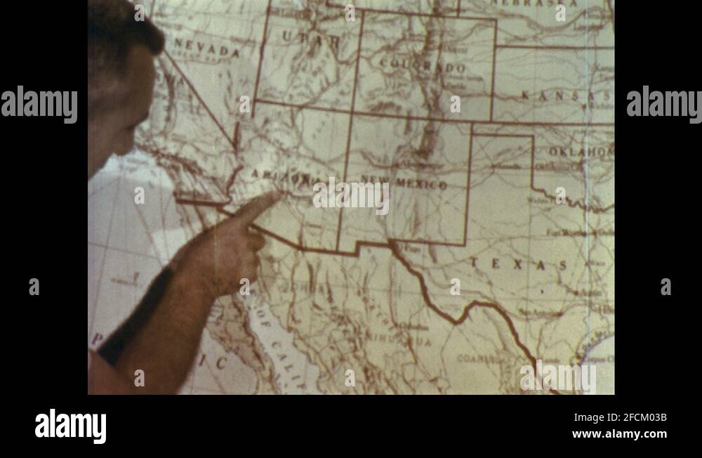 1950s: Man points to map of United States. Man points to legend of wall ...
