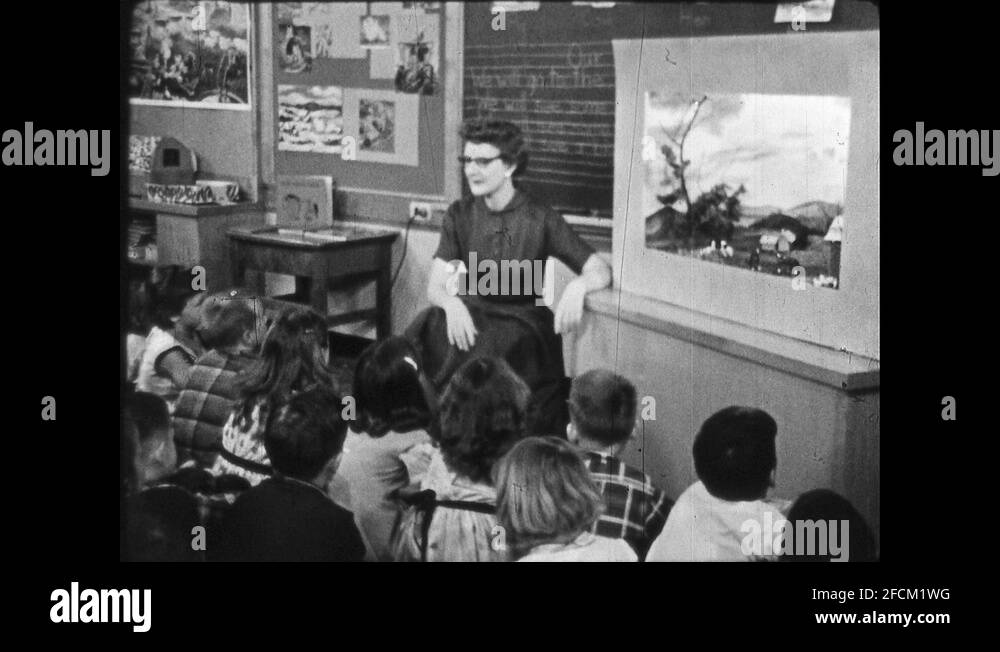 1950s: UNITED STATES: teacher in classroom. Children look at teacher in ...