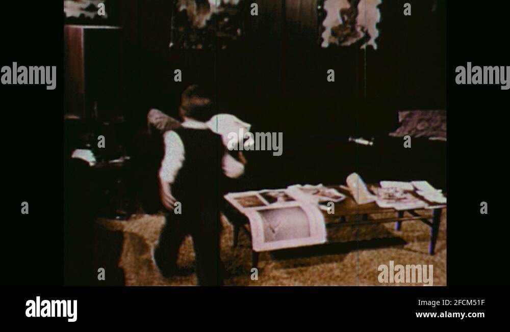 1970s: Boy runs into room with gun, jumps on couch, waves gun, man ...