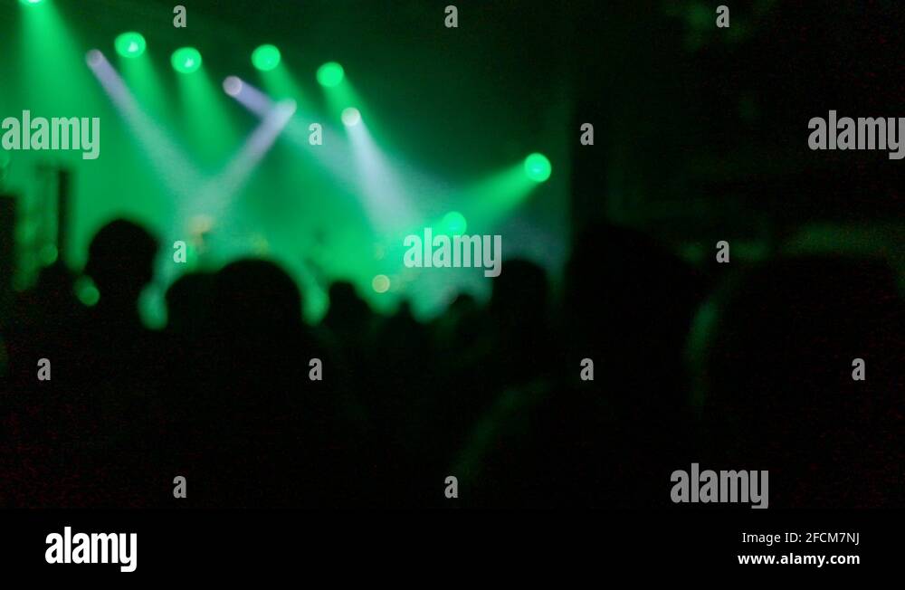 Blurred: rock concert in the club, green lights on stage, view from the ...