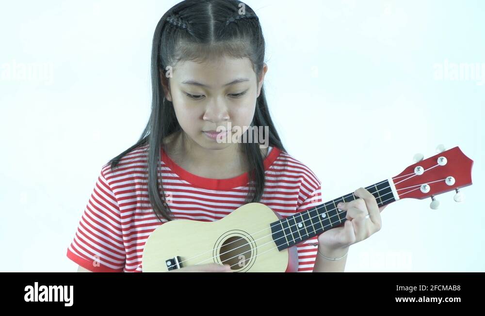 Young girls playing fun ukulele on a white background. 4k Resolution ...