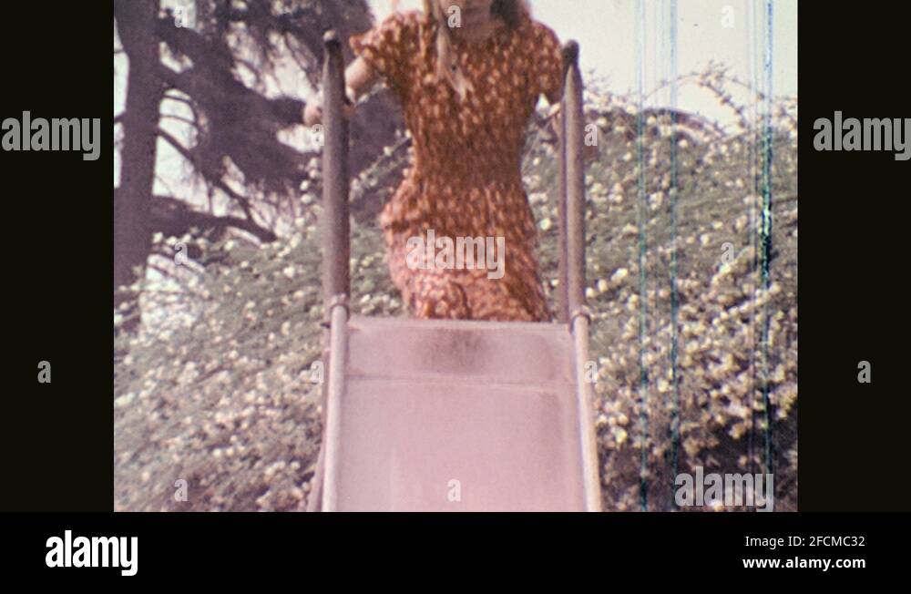 1970s: UNITED STATES: children play on slide. Children at swimming pool ...