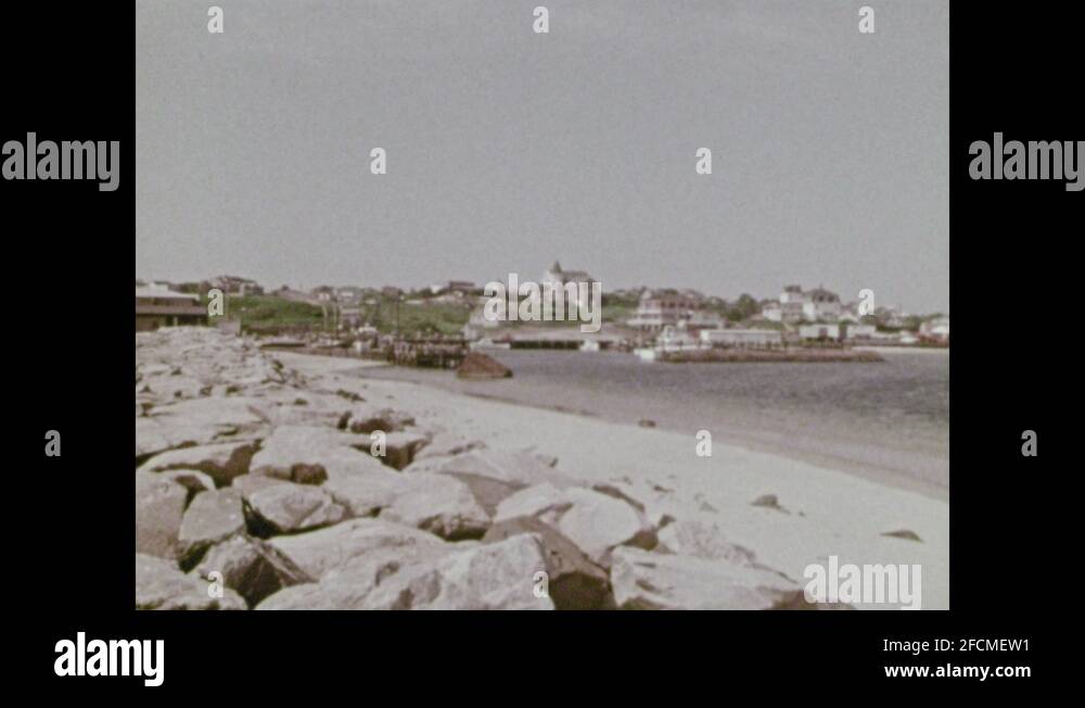 1970s: Small village along waterfront and rocky beach. Buildings in ...
