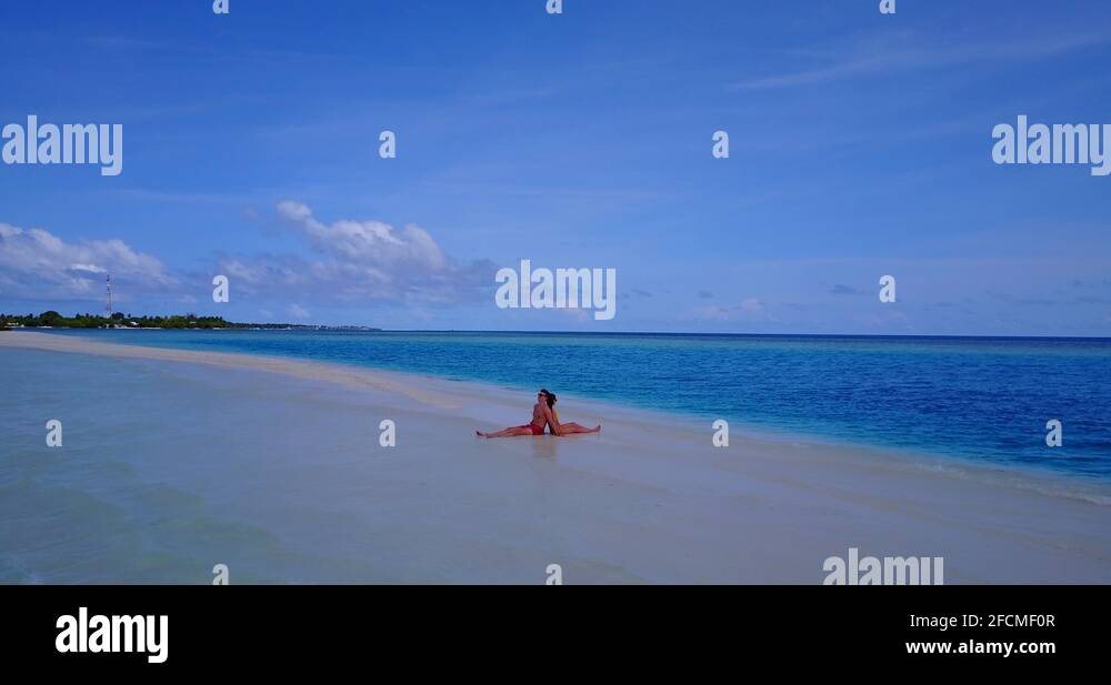 Footage of a romantic scene wih a couple laying on a sandbar on the ...
