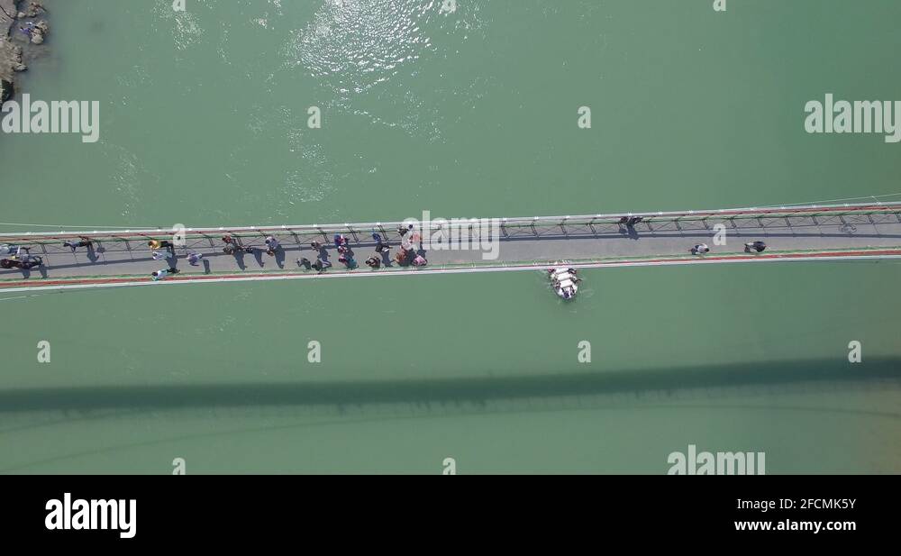 Lakshman Jhula Bridge flyover, with rafting boat on Ganges river below ...
