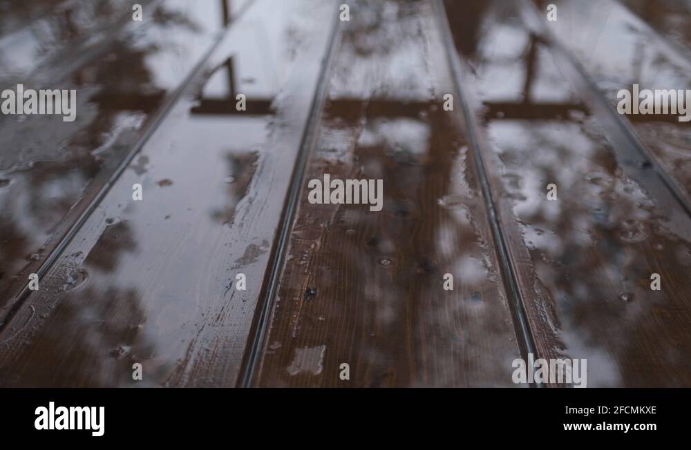 Drops of rain fall on the balcony, wet wood floor, around the forest ...