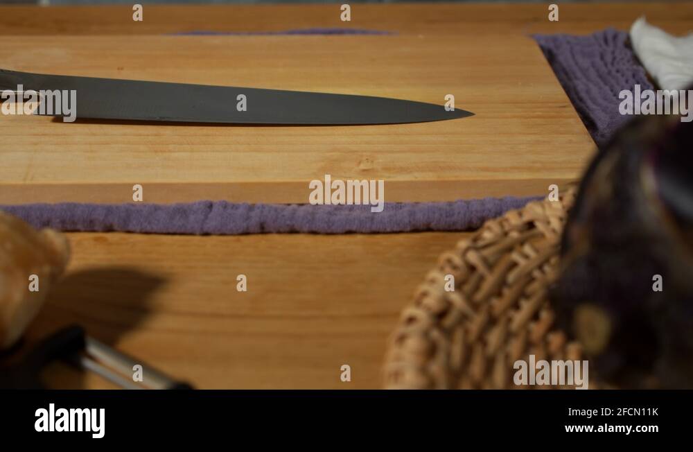 a Japanese female chef cutting off the edge of KAMONASU (Japanese round ...