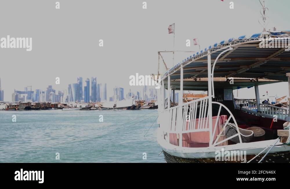 Traditional dhow boat floating in Qatar near the Doha cityscape skyline ...