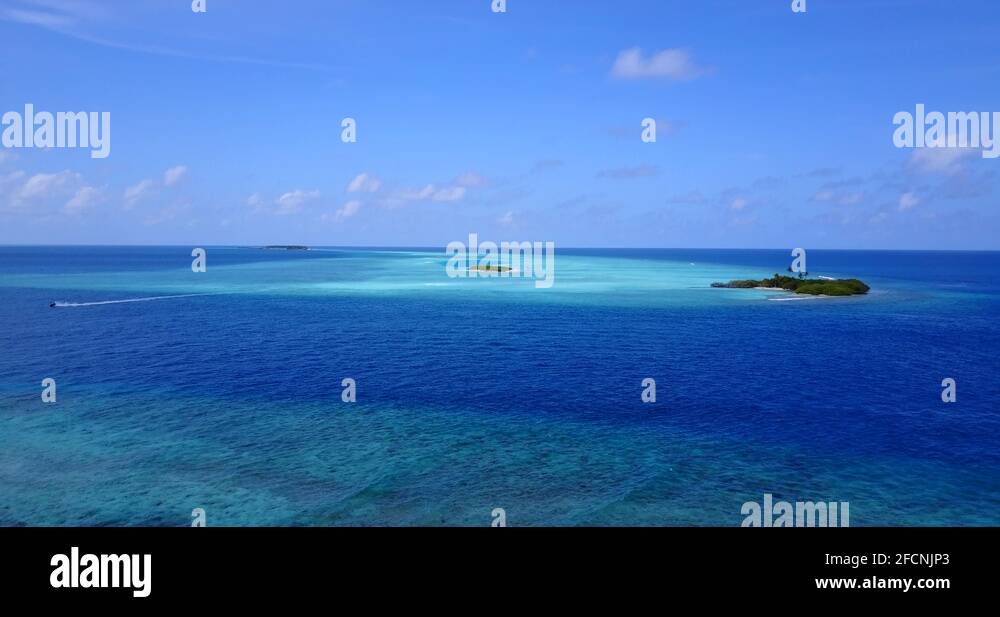 High above vivid blue and teal water while a jet ski drives by in the ...