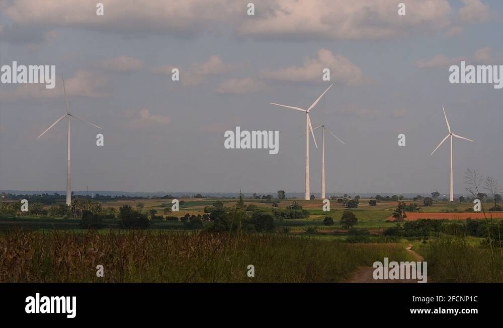 Wind Turbines Towering Farmlands, as farmers grow their crops and tend ...