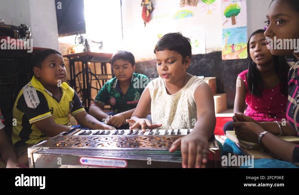 Poor orphan Asian children playing music on harmonium in primary ...