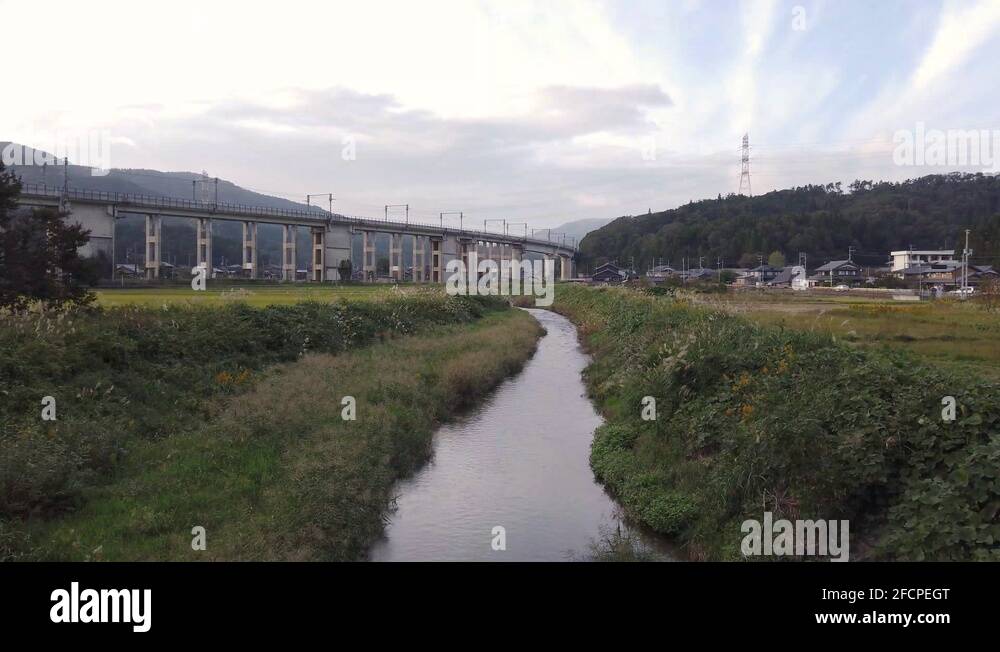 Rural Japanese Countryside with River leading into distance with train ...
